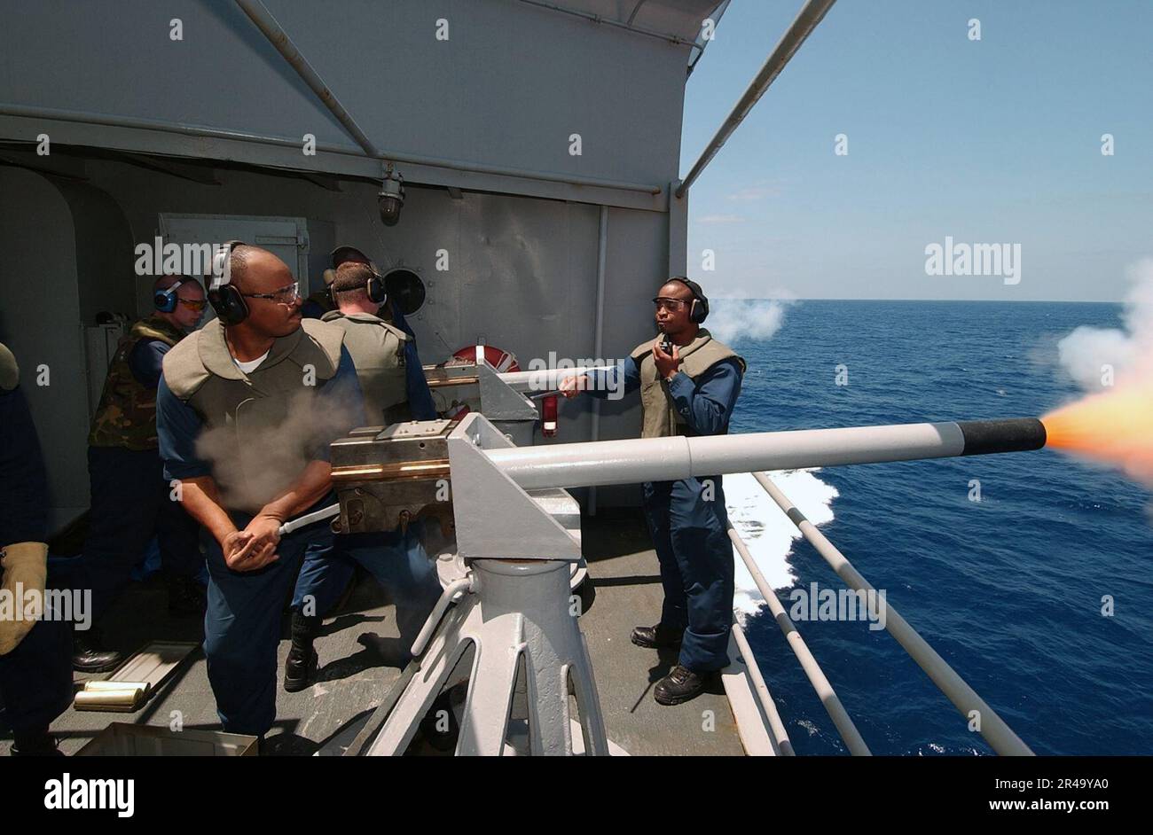 US Navy Sailor gives the signal to fire one of the 40mm saluting ...