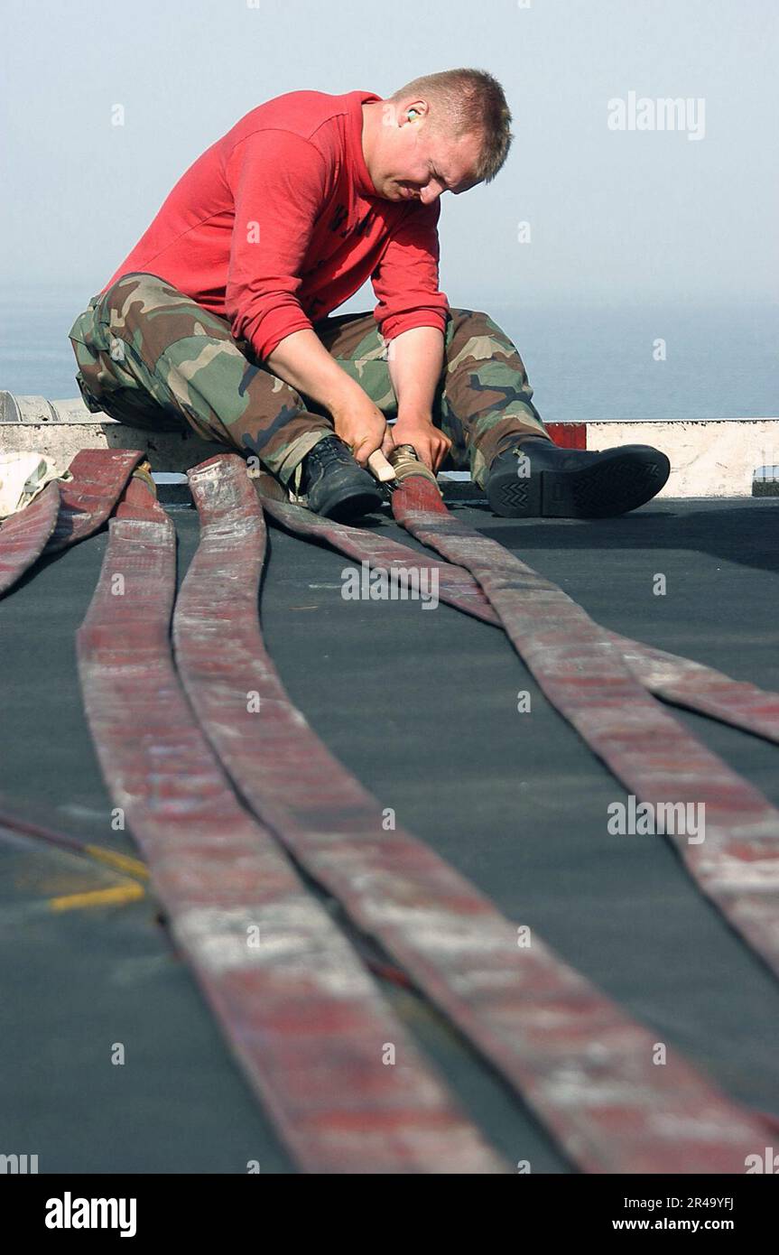 US Navy Aviation Boatswain's Mate completes preventative maintenance ...