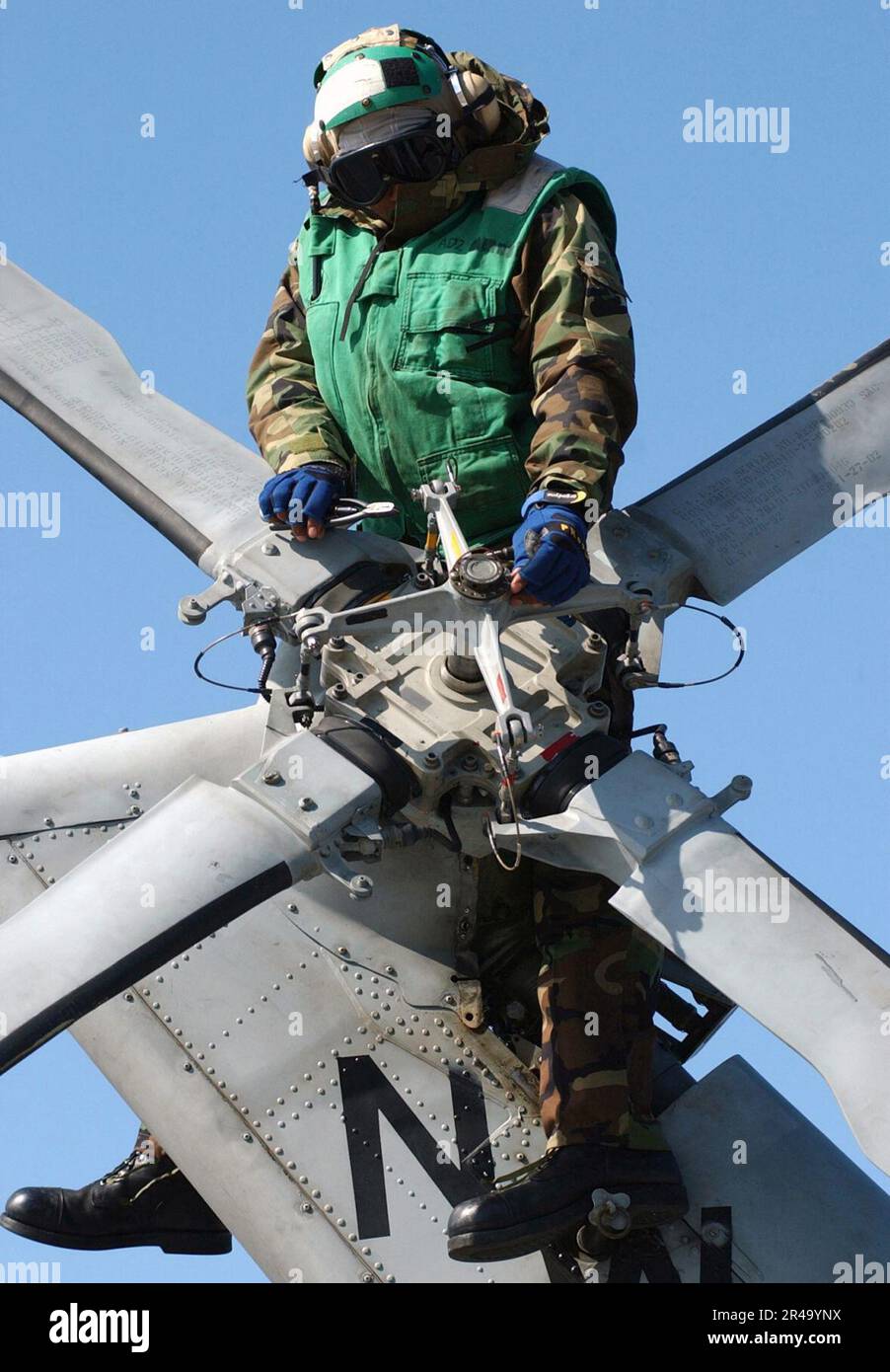 US Navy Aviation Machinist's Mate performs maintenance on the tail ...