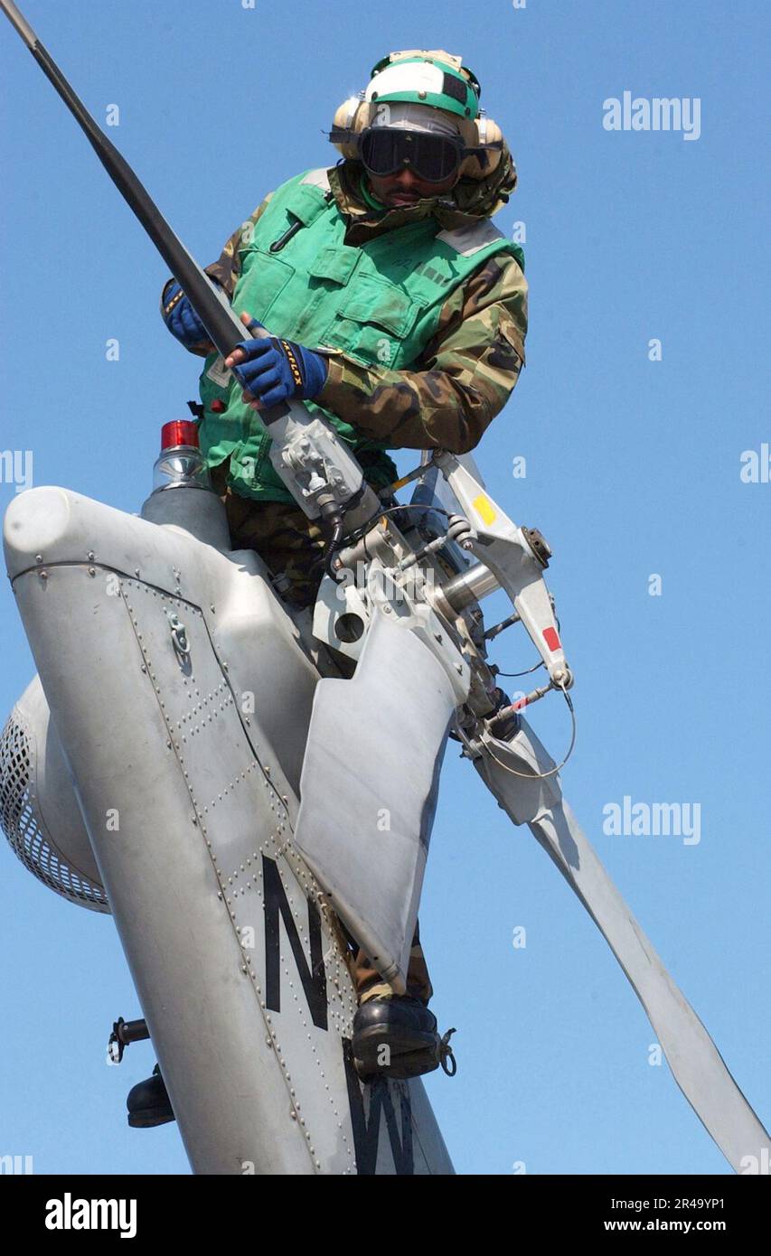 US Navy Aviation Machinist's Mate performs maintenance on the tail ...