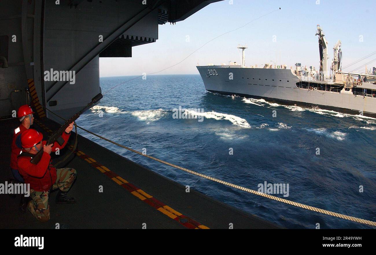 US Navy Gunner's Mate watches as Aviation Ordnanceman 1st Class shoots ...