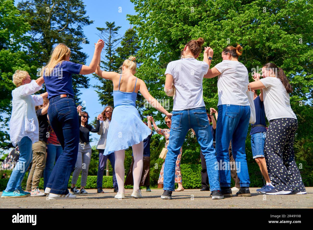 A group of people is having fun outside in the street, with some ...