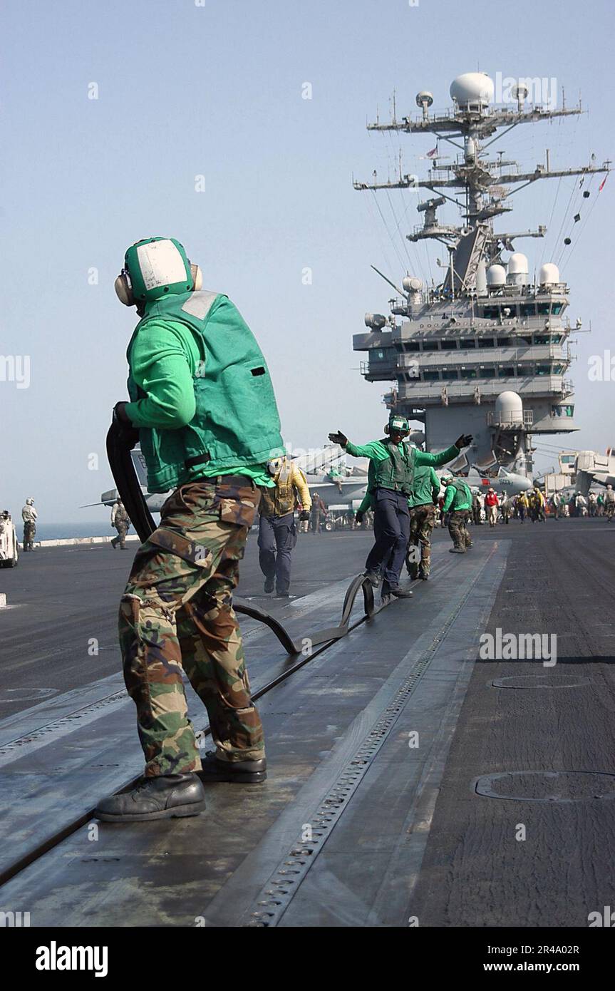 US Navy Air Department crewmembers remove the slot seal from catapult ...