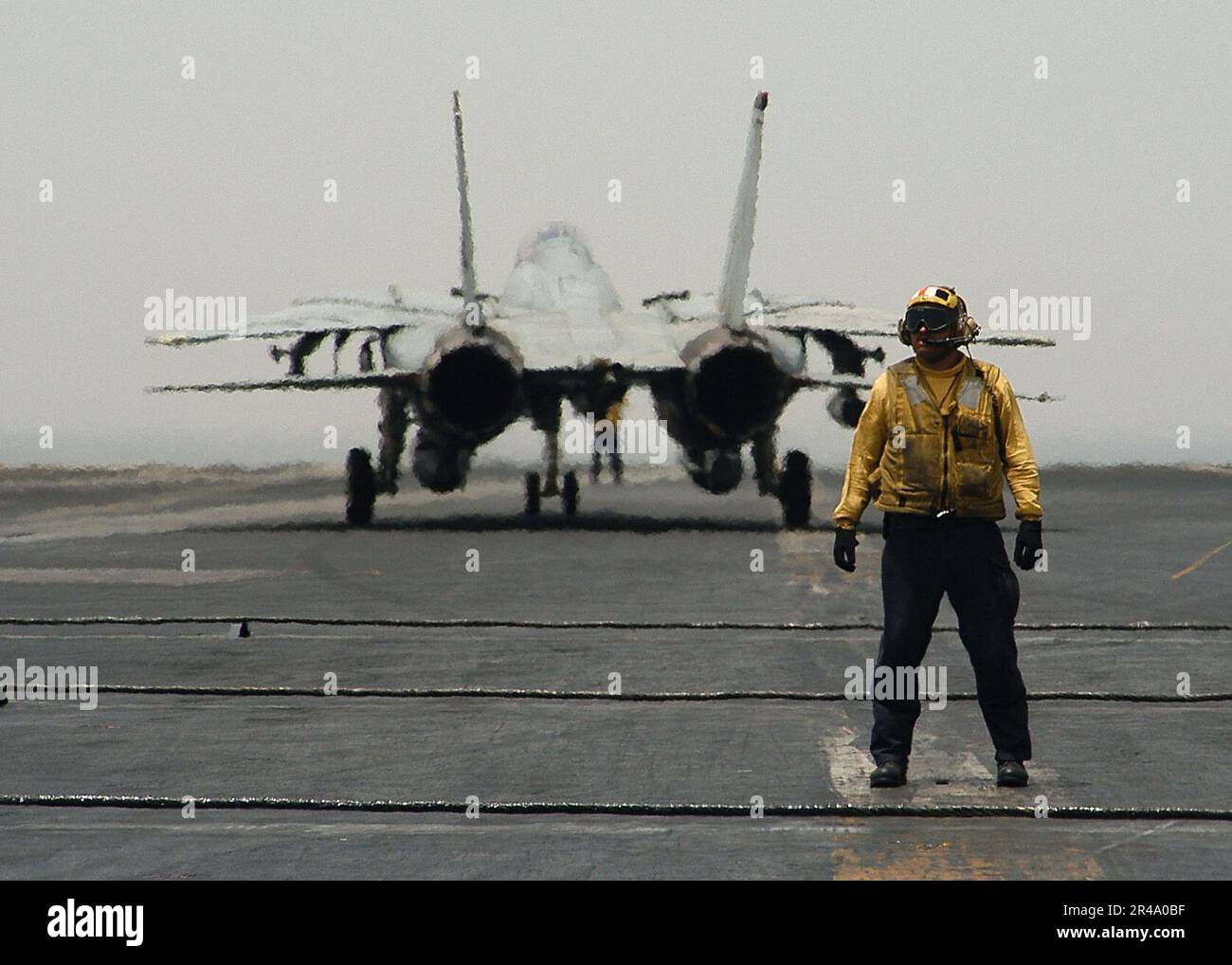 US Navy Aviation Boatswain's Mate 1st Class awaits the next aircraft to ...