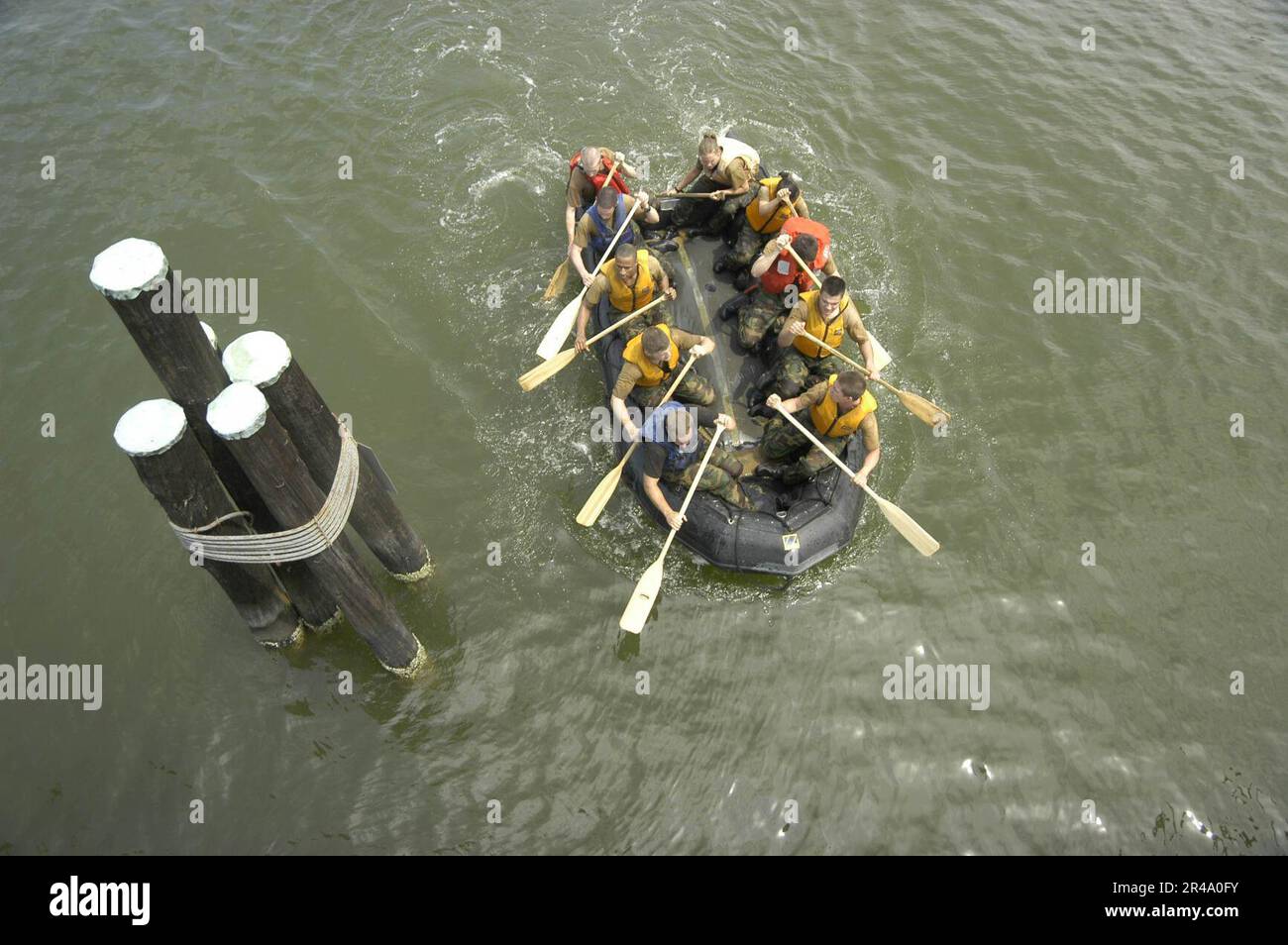 US Navy A squad of Midshipmen paddle a rubber boat under a footbridge ...