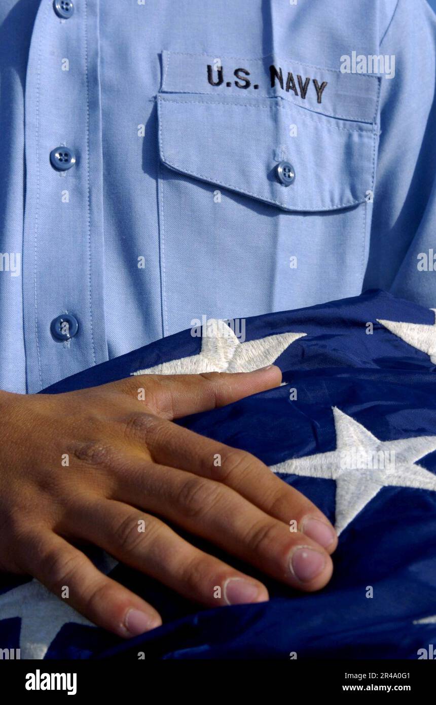 US Navy A Sailor holds the national ensign in preparation of the call ...