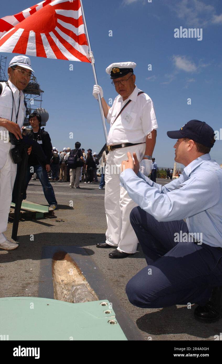 US Navy A Sailor explains the operation of a flight deck catapult to ...