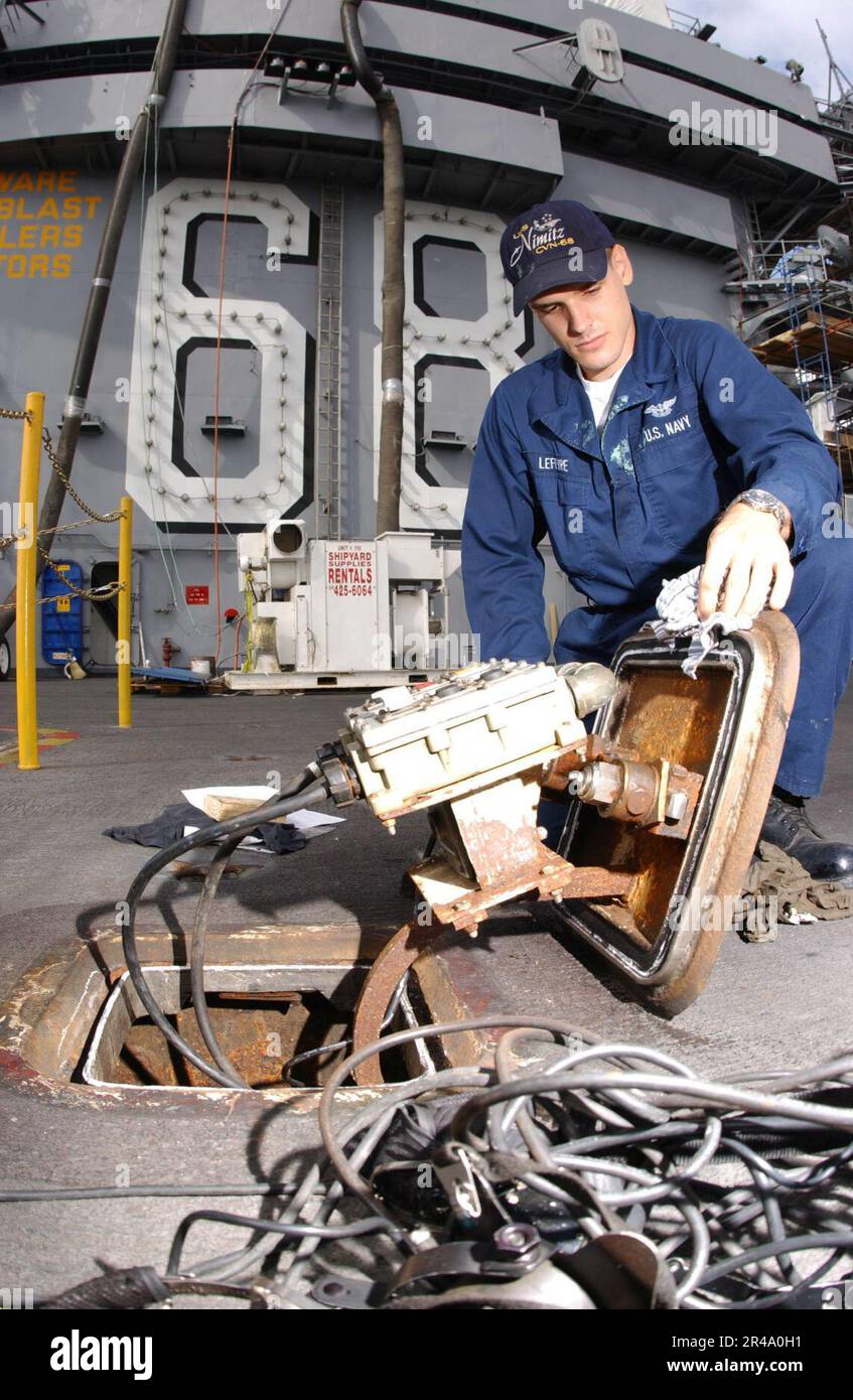 US Navy Airman scrubs corrosion off a control box while conducting a ...