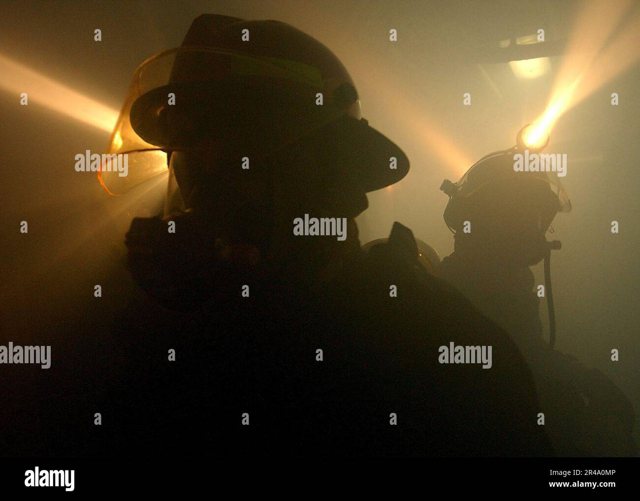 US Navy Repair locker members investigate a smoke filled space during a ...