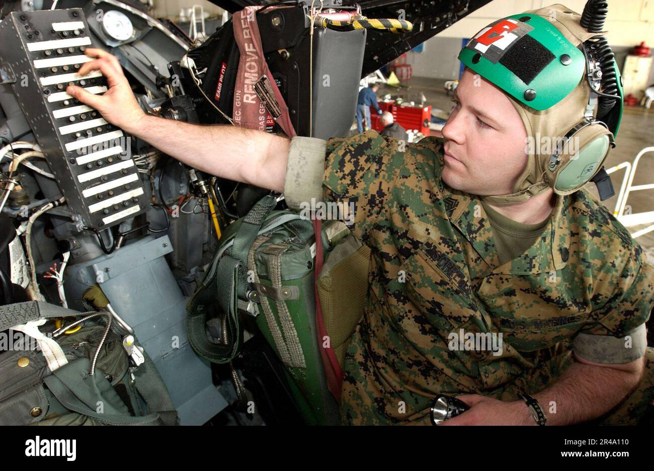 US Navy U.S. Marine Corps inspects circuit breakers in the cockpit of ...