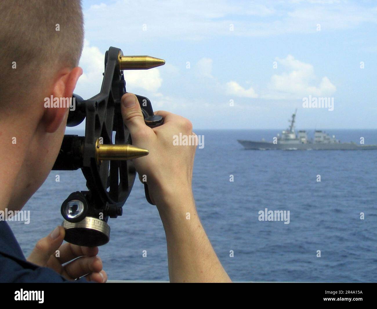 US Navy Quartermaster Seaman uses a stadimeter to determine the range ...