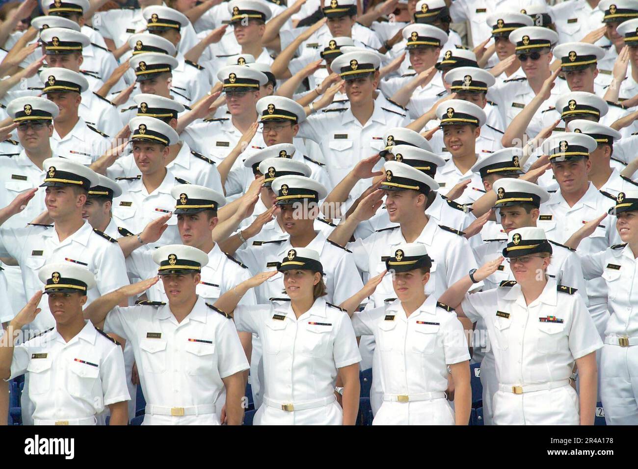 US Navy Midshipmen stand and salute the colors during the U.S. Naval ...