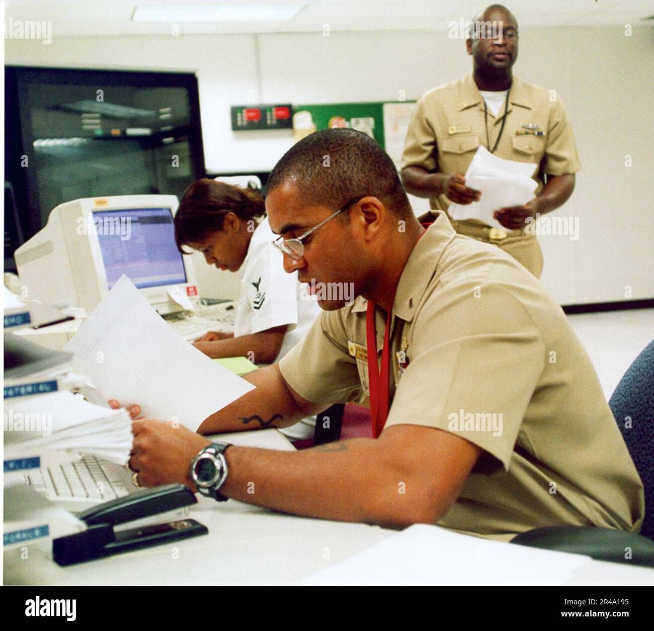US Navy Lt.j.g. Message Center Division Officer, works at a computer ...