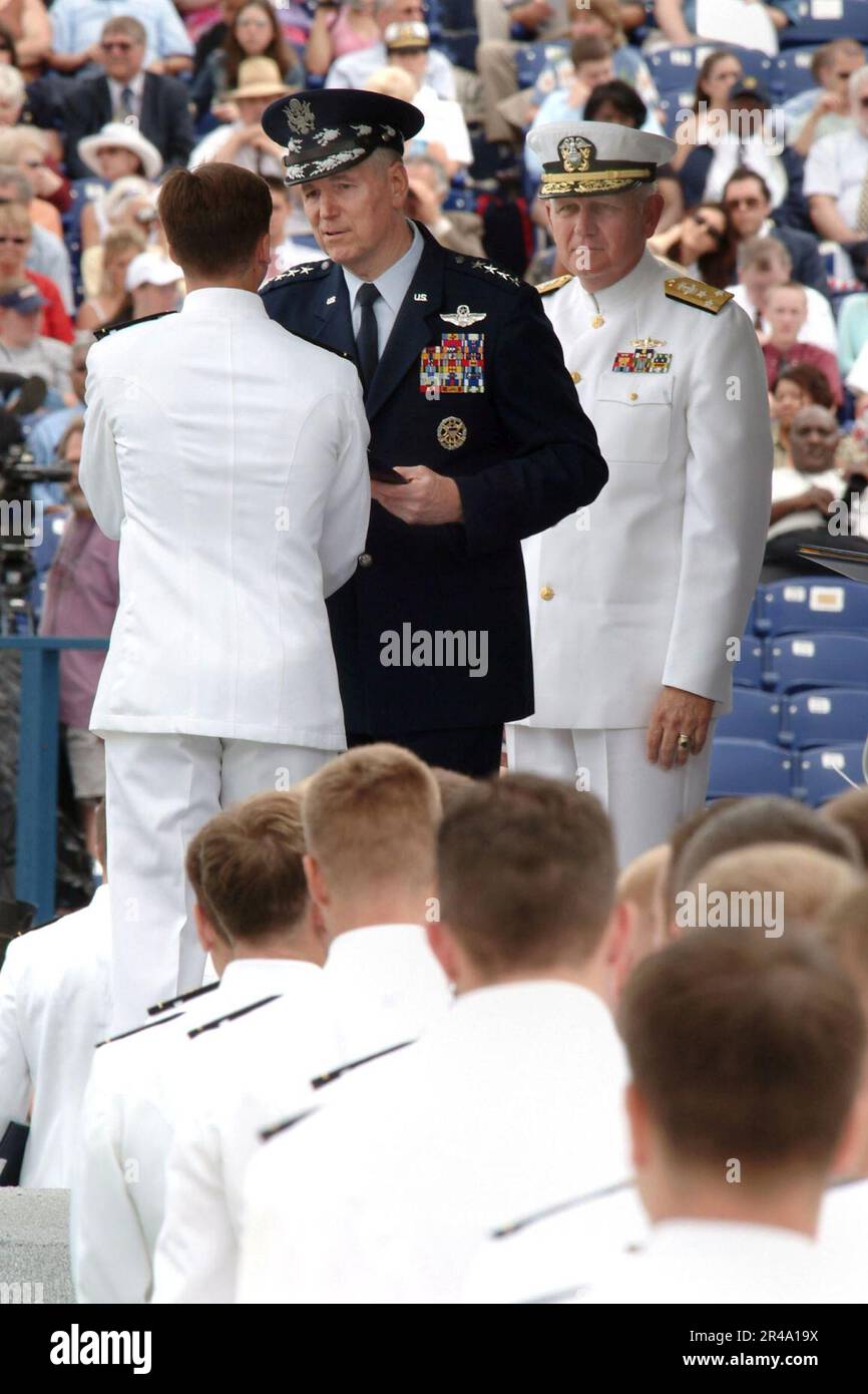 US Navy A newly commissioned Ensign receives his diploma from the ...