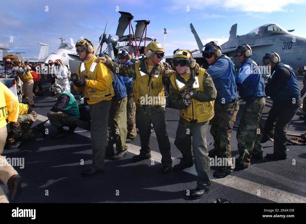US Navy Flight deck personnel work together to battle a simulated ...
