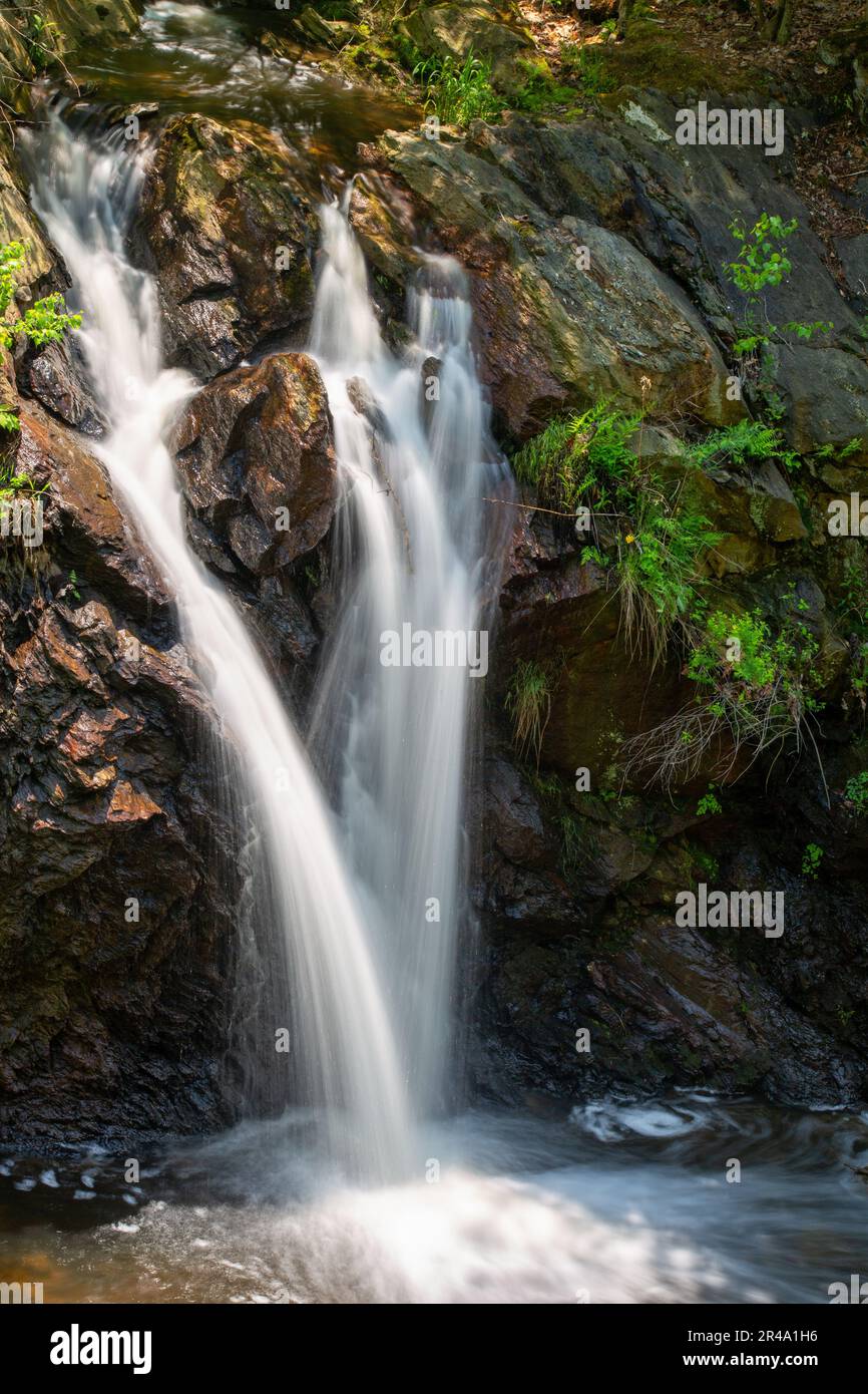 Serene waterfall cascades down rocky cliffs hi-res stock photography ...