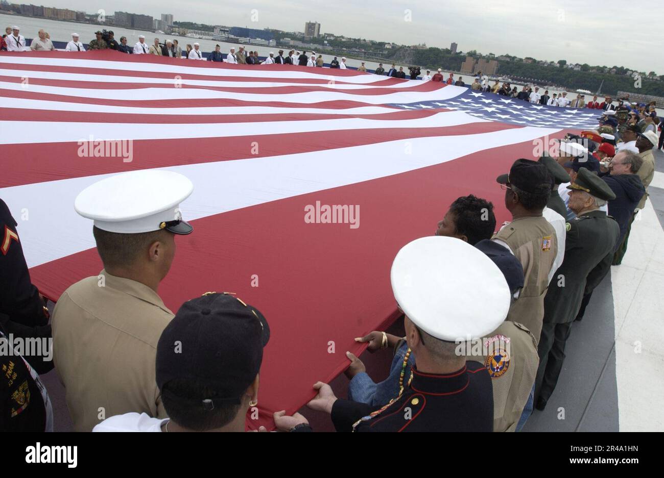 US Navy Sailors, Marines and military veterans hold a large American ...