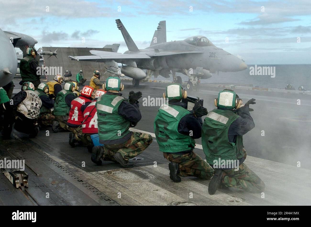 US Navy Flight deck personnel signal to suspend launch for an F-A-18C ...