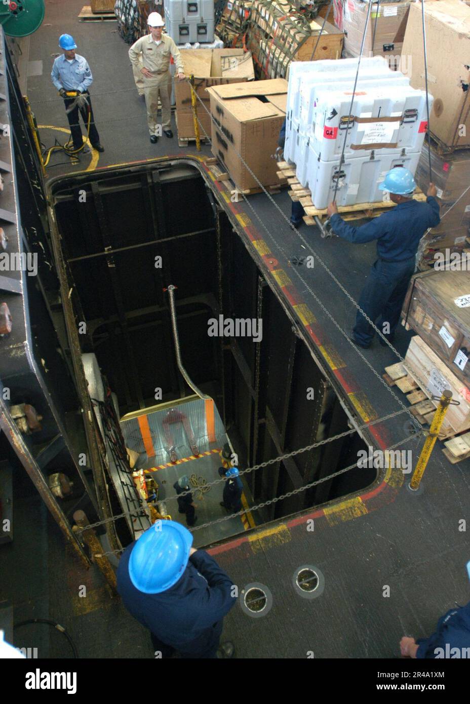 US Navy Supply Department personnel transfer a pallet of cargo from the ...