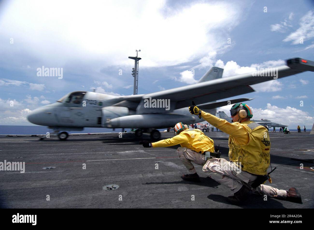 US Navy Two flight deck shooters aboard USS John F. Kennedy (CV 67), signals the launch off an S ...