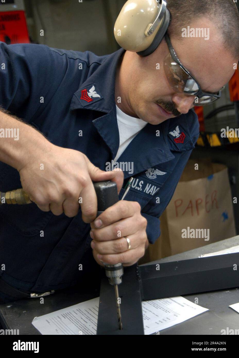 US Navy Aviation Structural Mechanic 1st Class drills a hole into a ...