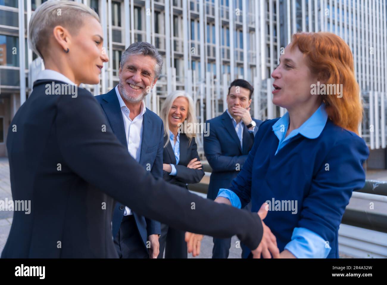 A group of business professionals having a conversation outside a ...