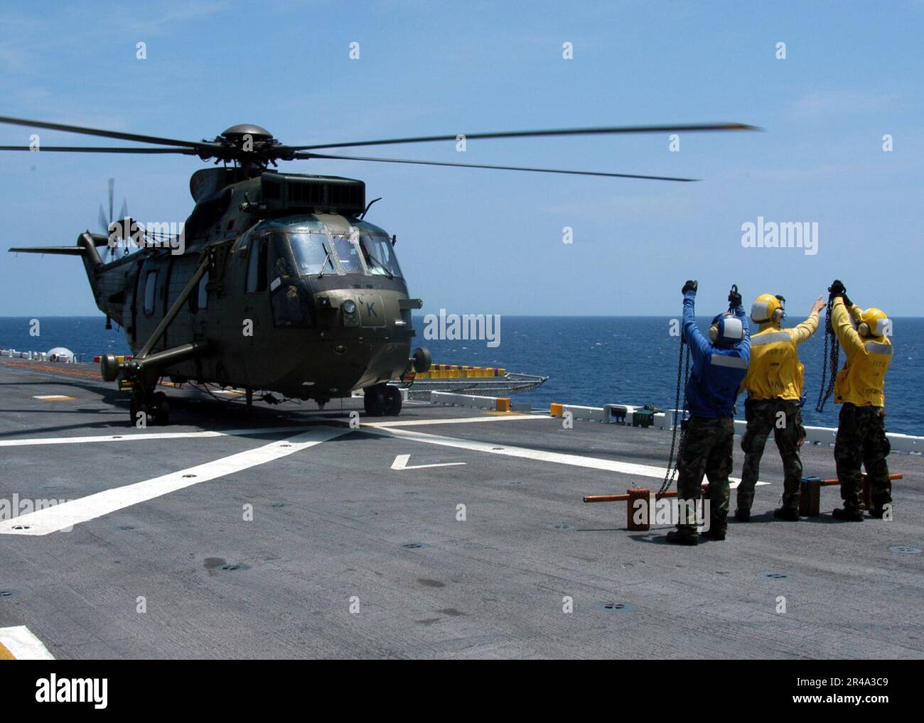 US Navy Crew Members assigned to the amphibious assault ship USS Nassau ...