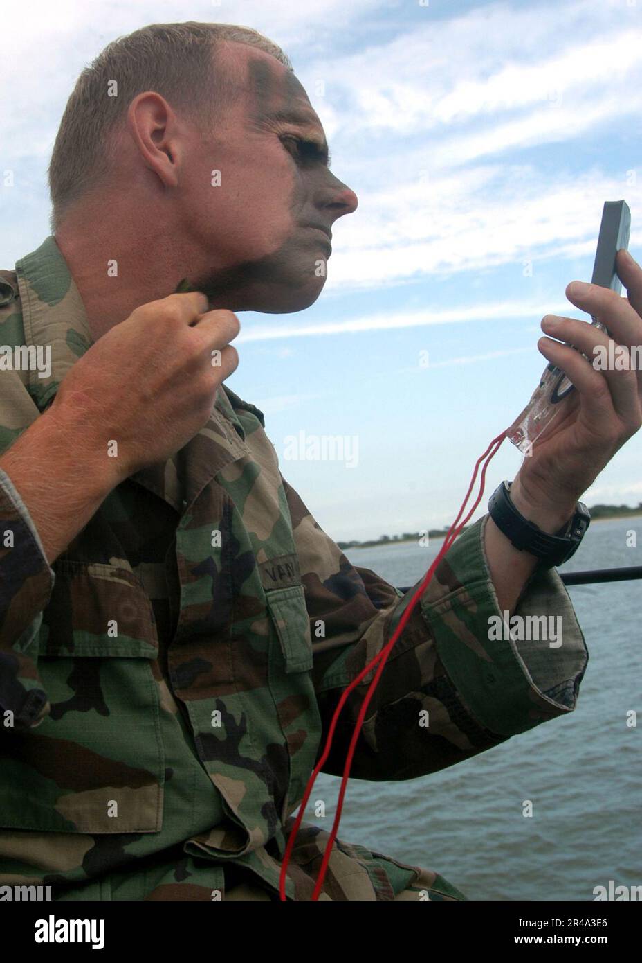 US Navy Dutch Marine Sgt. applies face paint in preparation for a beach ...