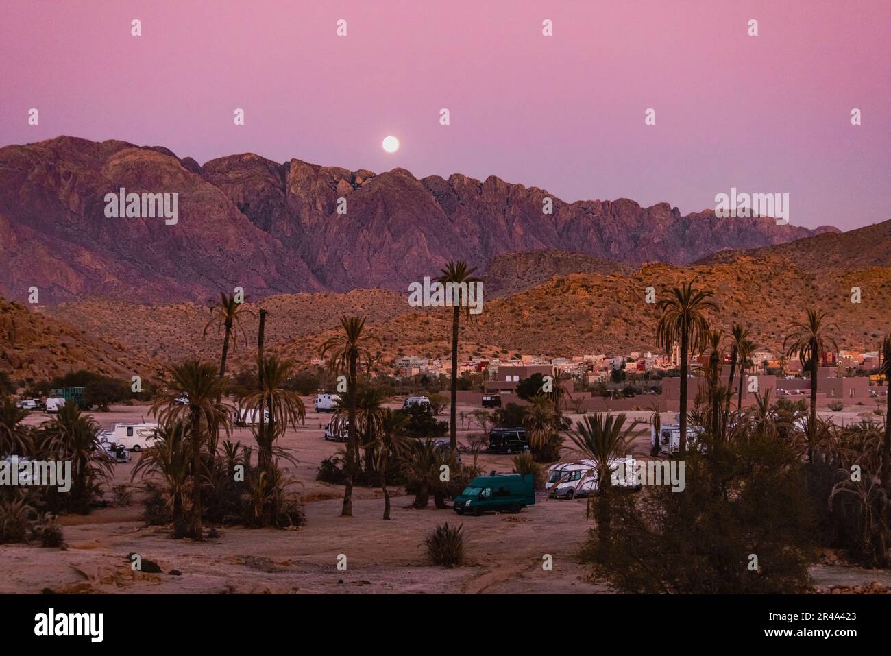 A scenic view of the full moon rising over red granite mountains, the ...