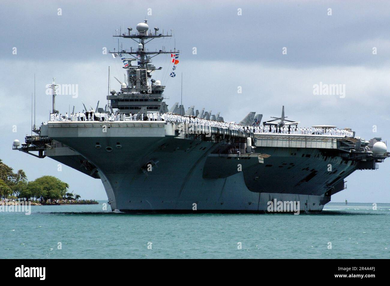 US Navy Sailors man the rails aboard the Nimitz-class aircraft carrier USS John C. Stennis CVN ...