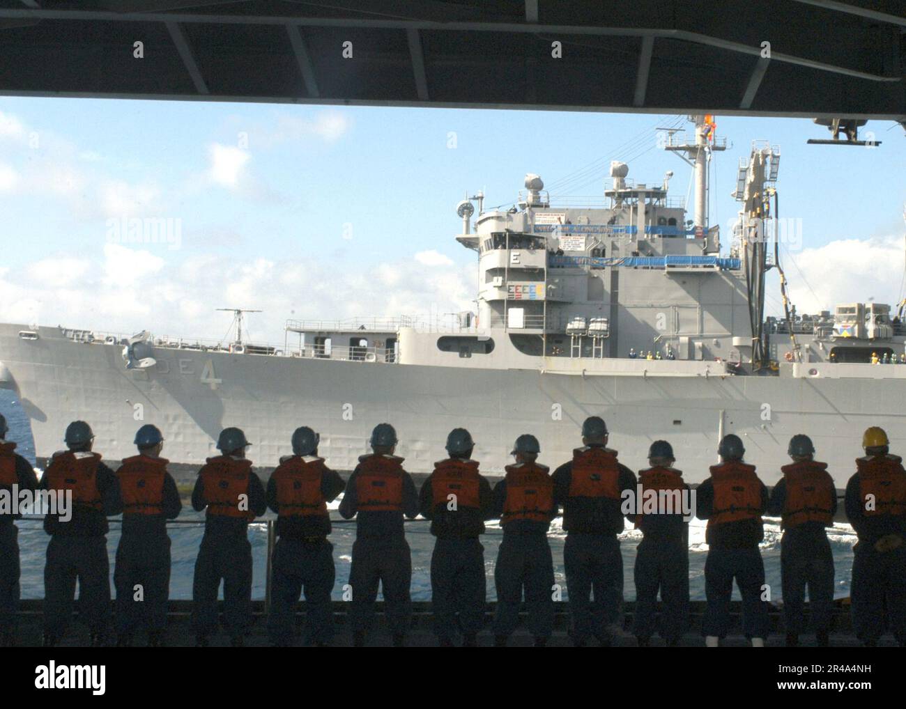 US Navy Sailors line up in front an elevator one in the ship's hangar ...