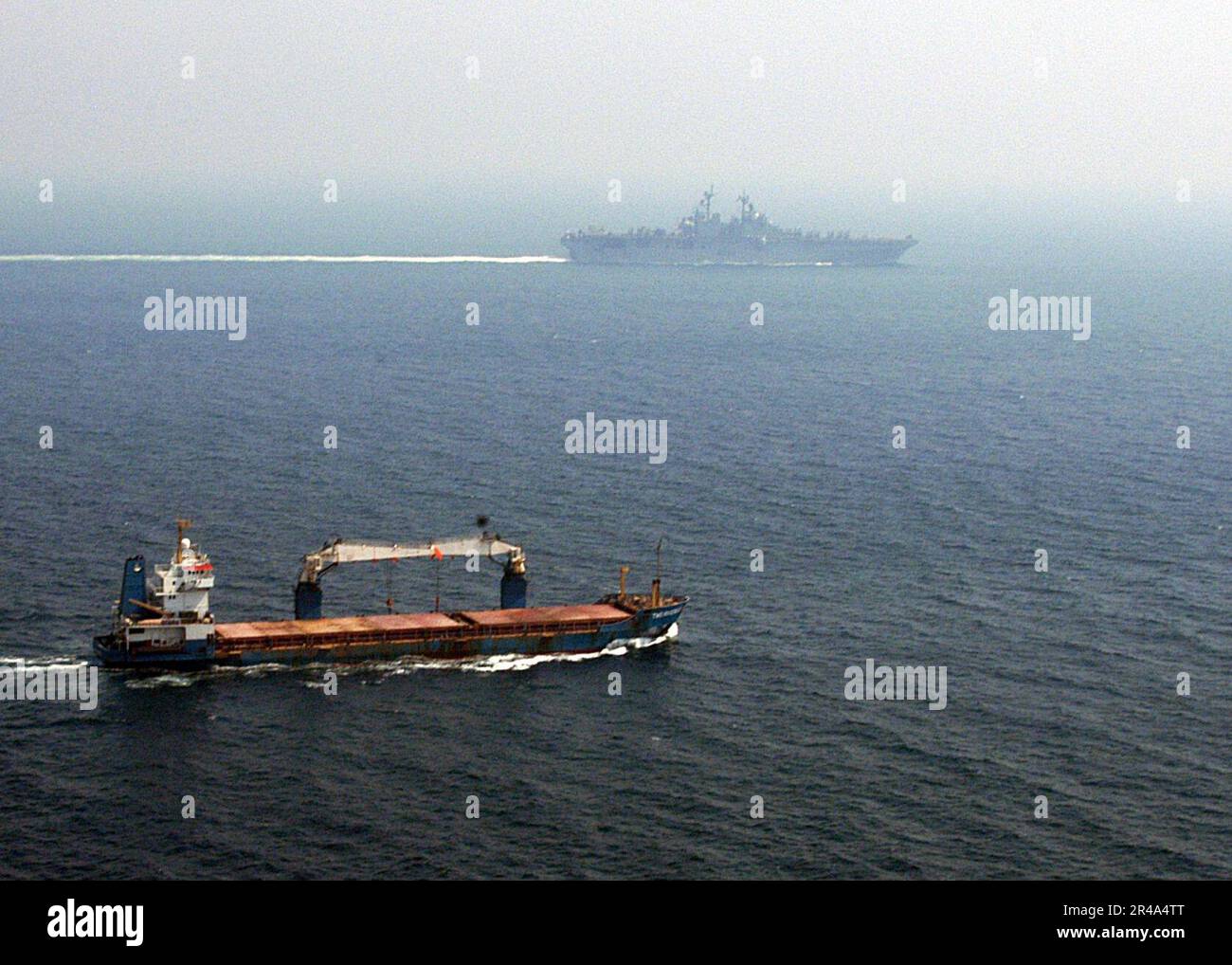 US Navy A merchant ship sails off the starboard side of the amphibious ...