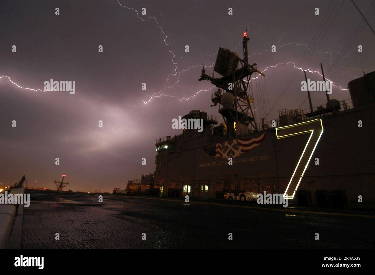 US Navy Lightning brightens an evening sky as seen from the flight deck ...