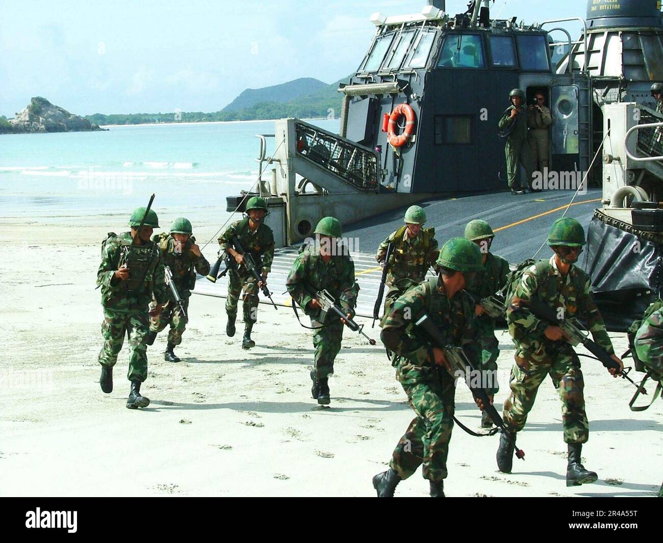 US Navy Royal Thai Marines storm ashore from a U.S. Navy Landing Craft ...