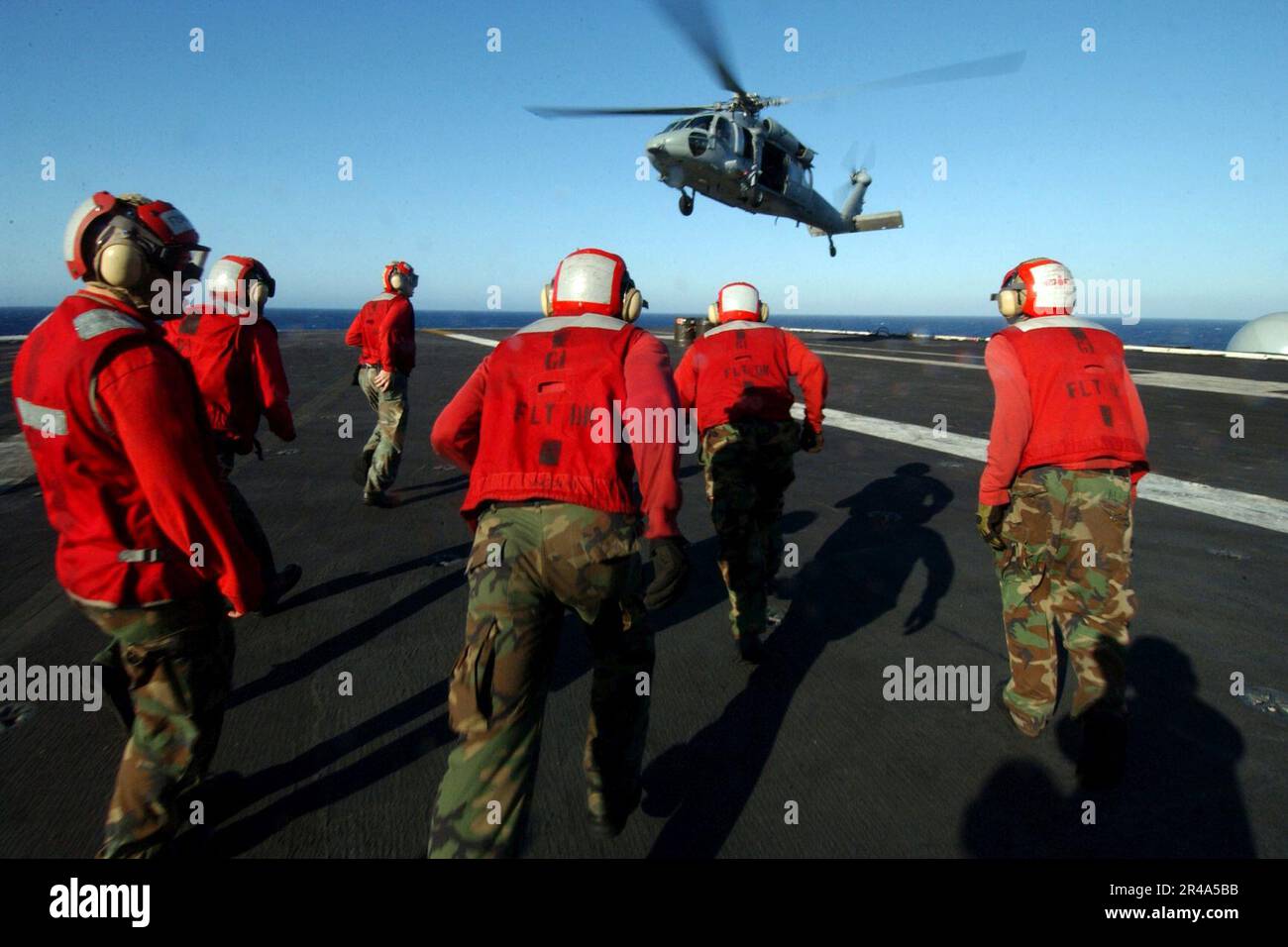 US Navy Aviation Ordnancemen rush to retrieve ordnance delivered by an ...