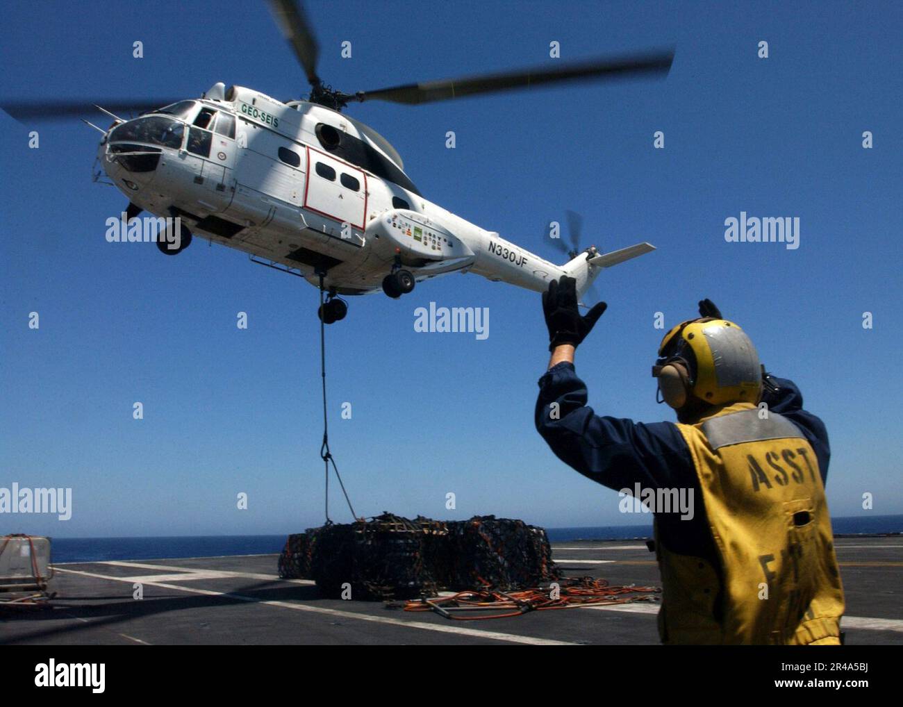 US Navy A flight deck director signals to an SA 330J Puma helicopter, during a vertical ...