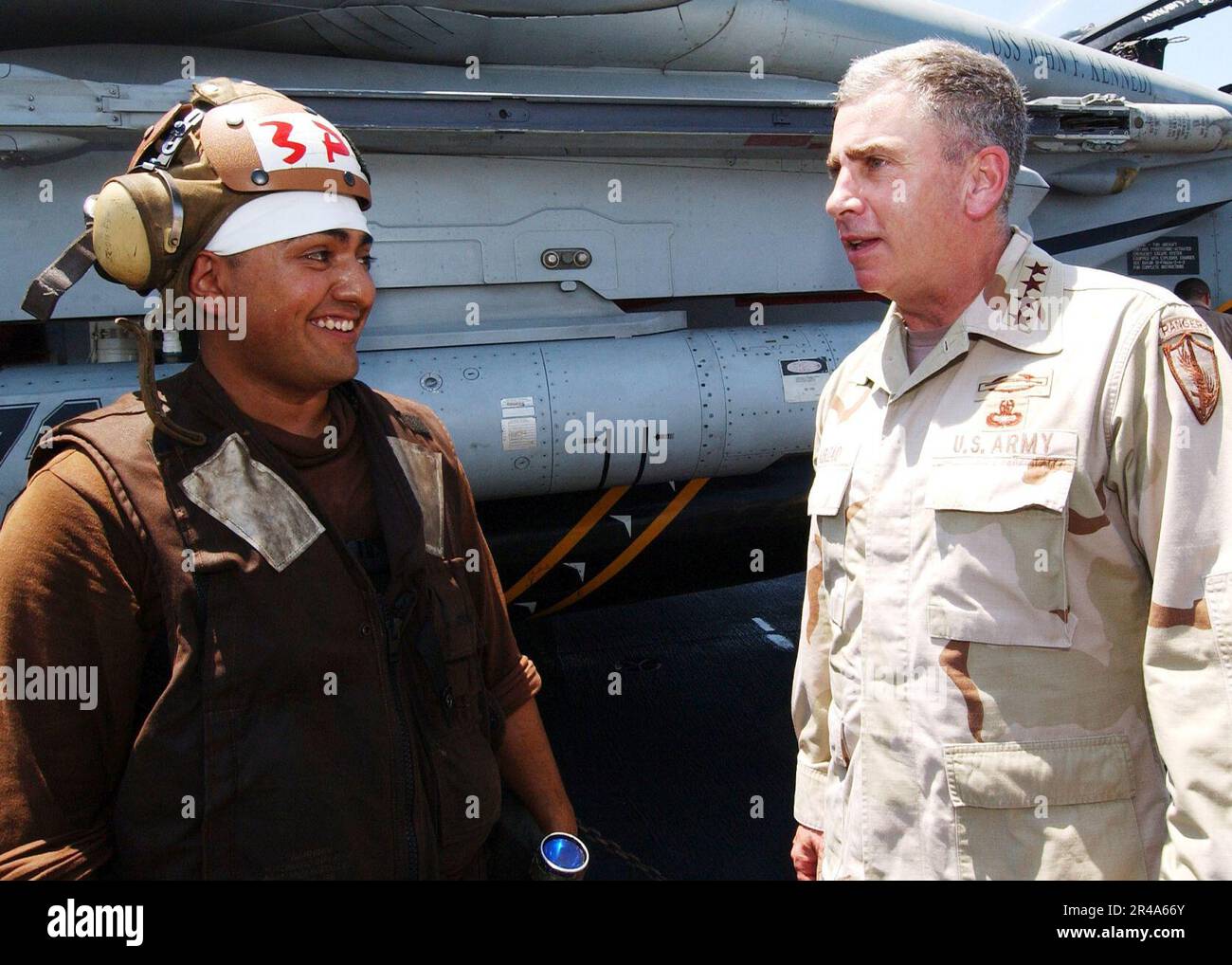 US Navy A member of the flight deck crew speaks with General John ...