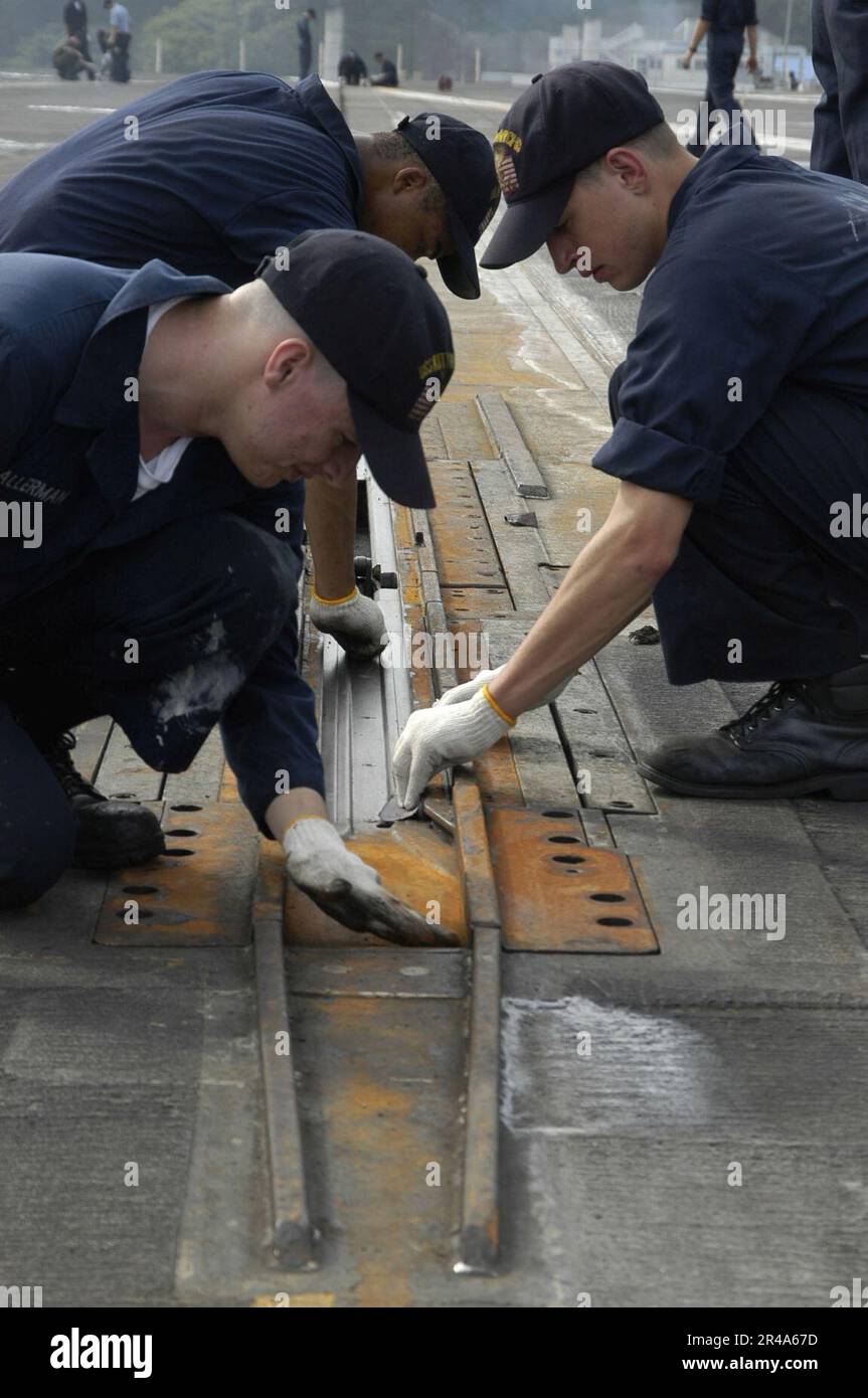 US Navy Air department personnel help clean off one of four steam ...