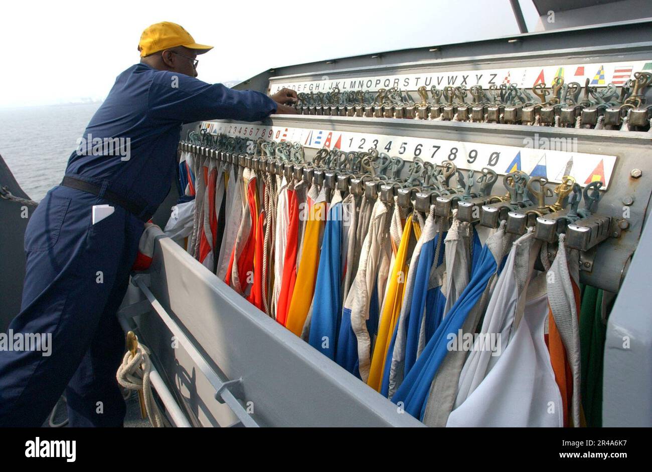 US Navy Boatswain's Mate 1st Class lowers the code hotel flag during ...