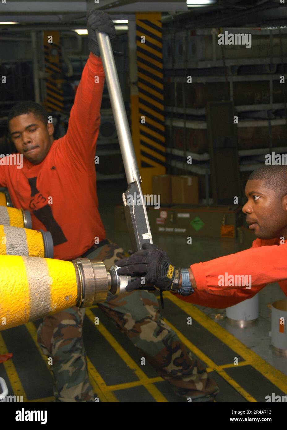 US Navy Aviation Ordnanceman tighten down the retainer ring of a MK-82 ...