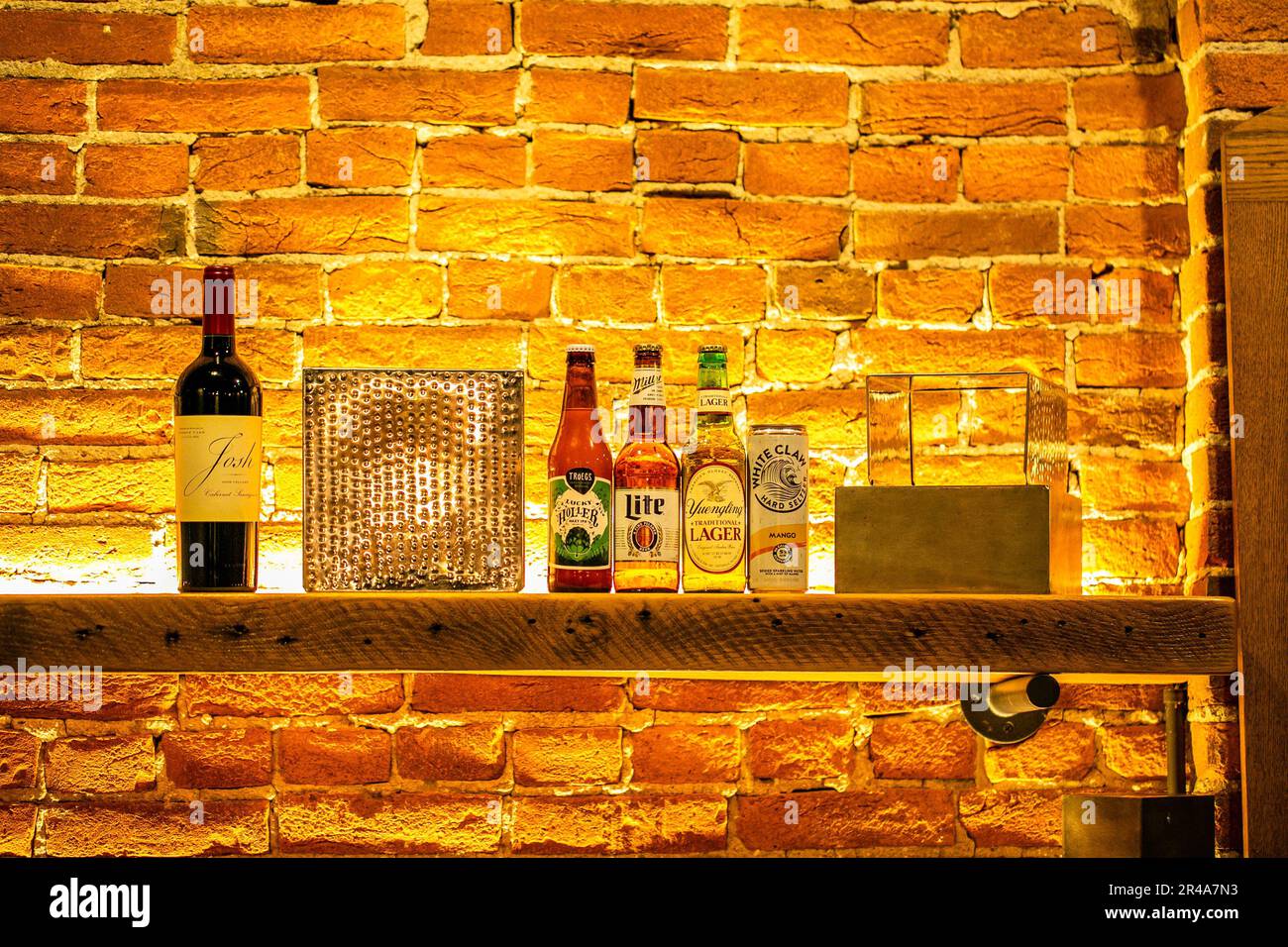 An image of two bottles of alcohol on a bar counter in a brick walled ...