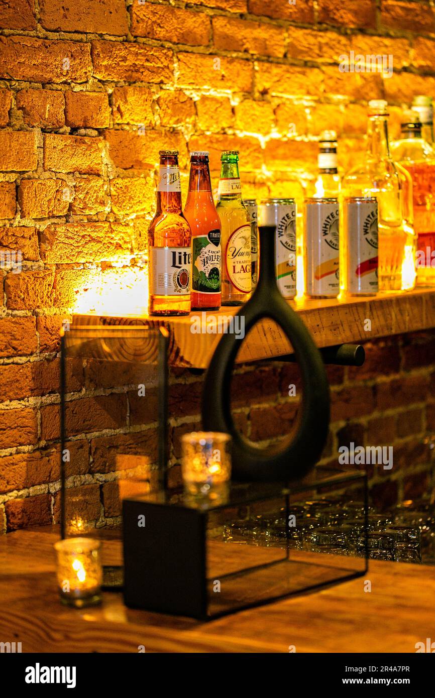 A close-up of a shelf of various types of alcoholic beverage bottles ...