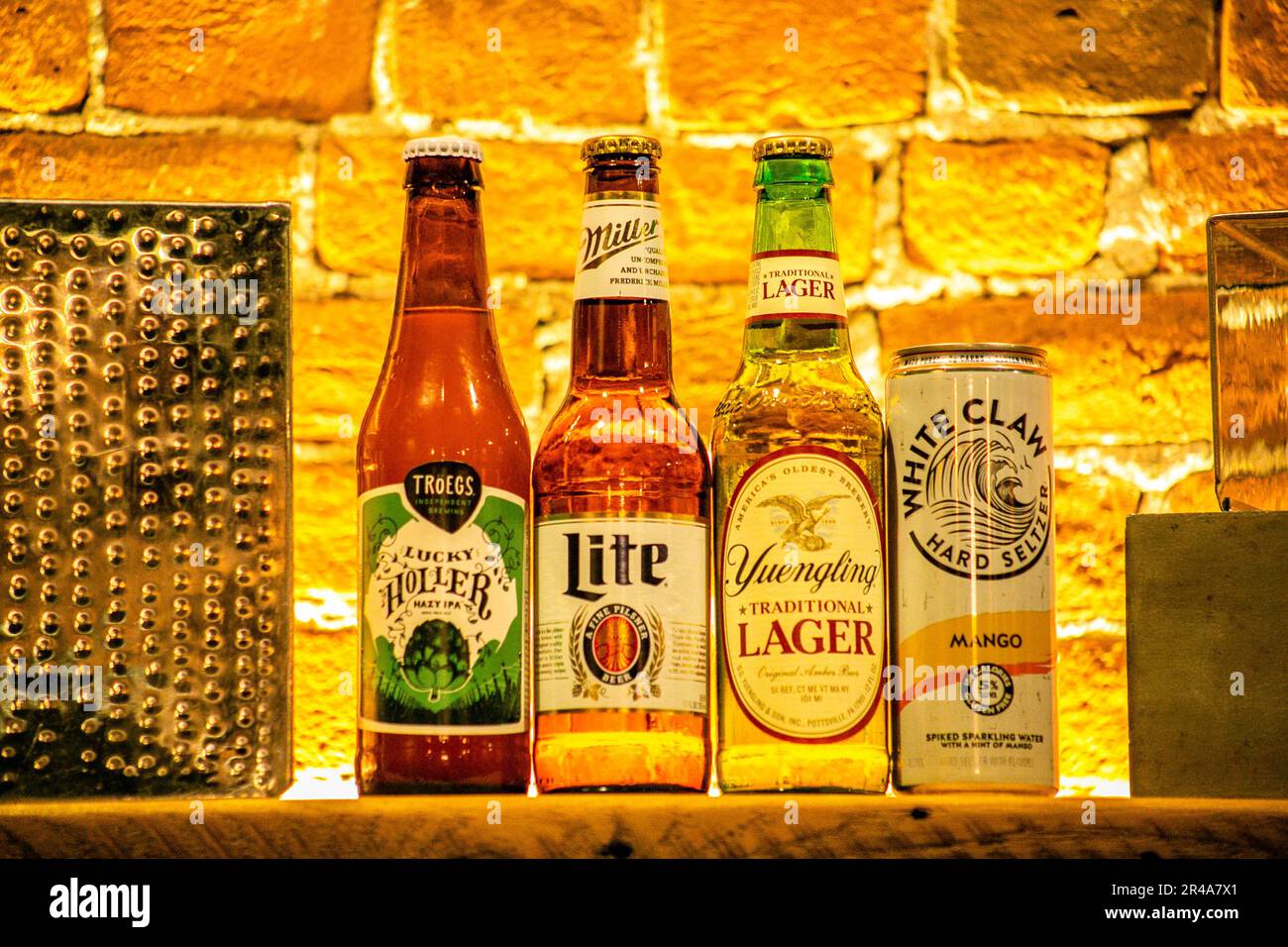 A close-up of a shelf of various types of alcoholic beverage bottles ...