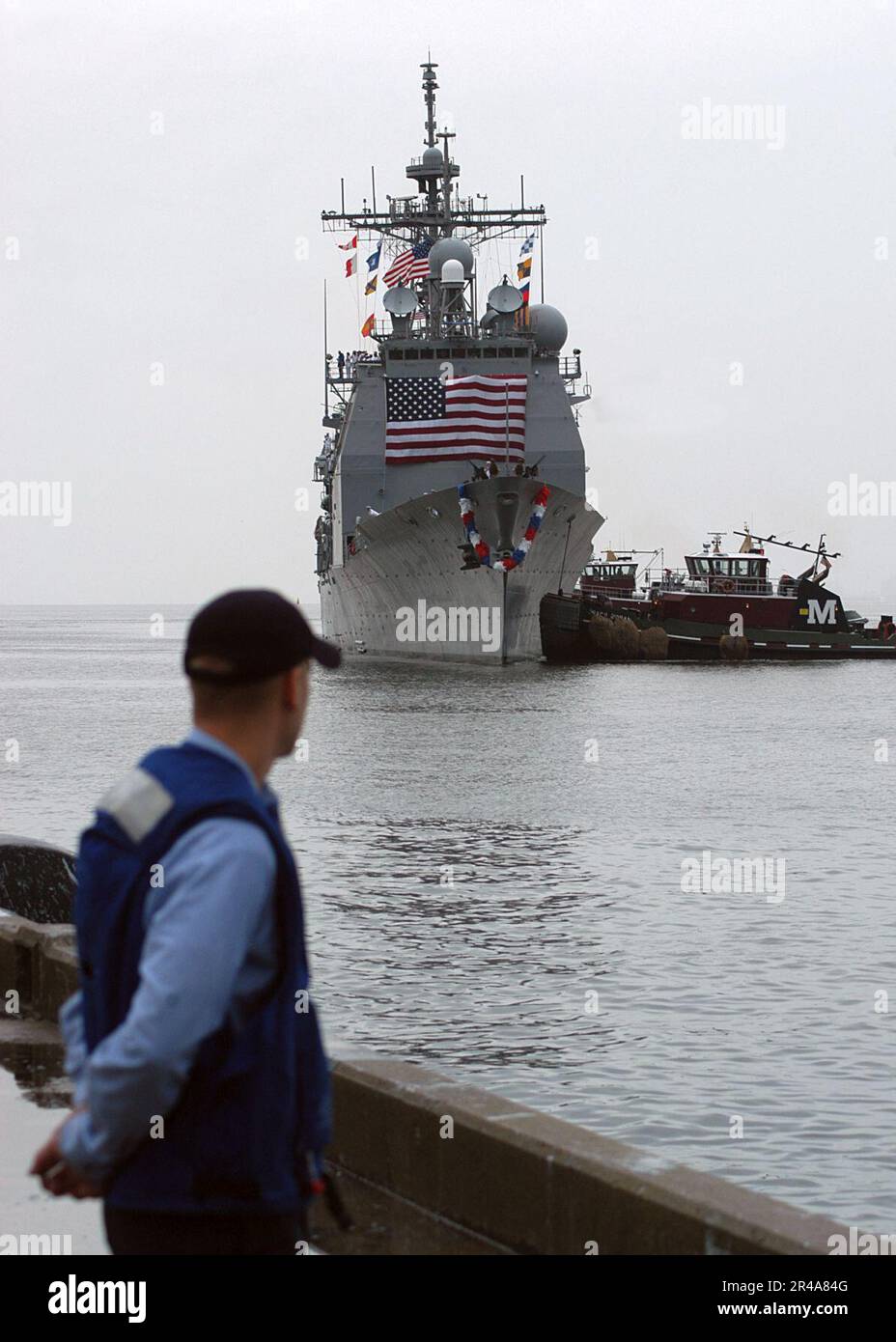US Navy A line handler waits on the pier for the guided missile cruiser ...