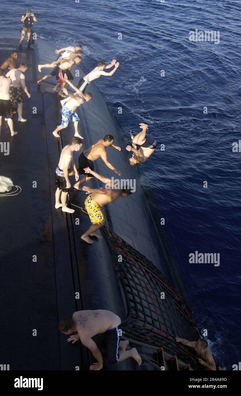 US Navy Crew members stationed aboard USS Portsmouth (SSN 707) leap ...