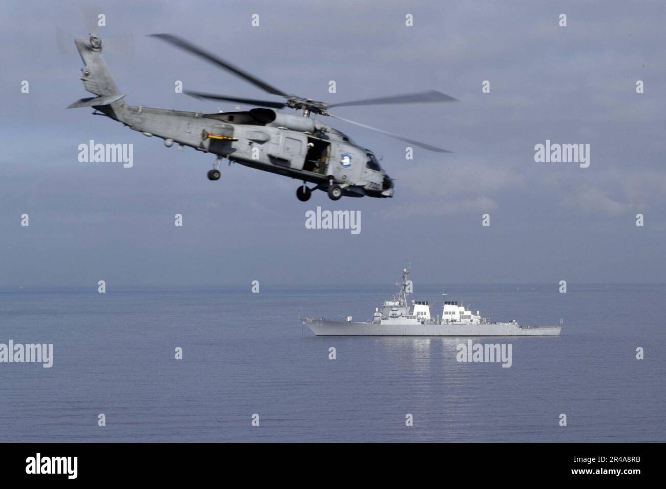 US Navy An SH-60B Seahawk passes the guided missile destroyer USS ...