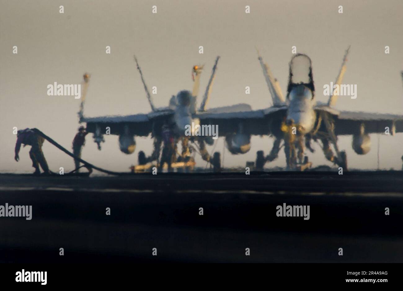 US Navy An Aviation Boatswain's Mate stretches a fuel hose across the ...