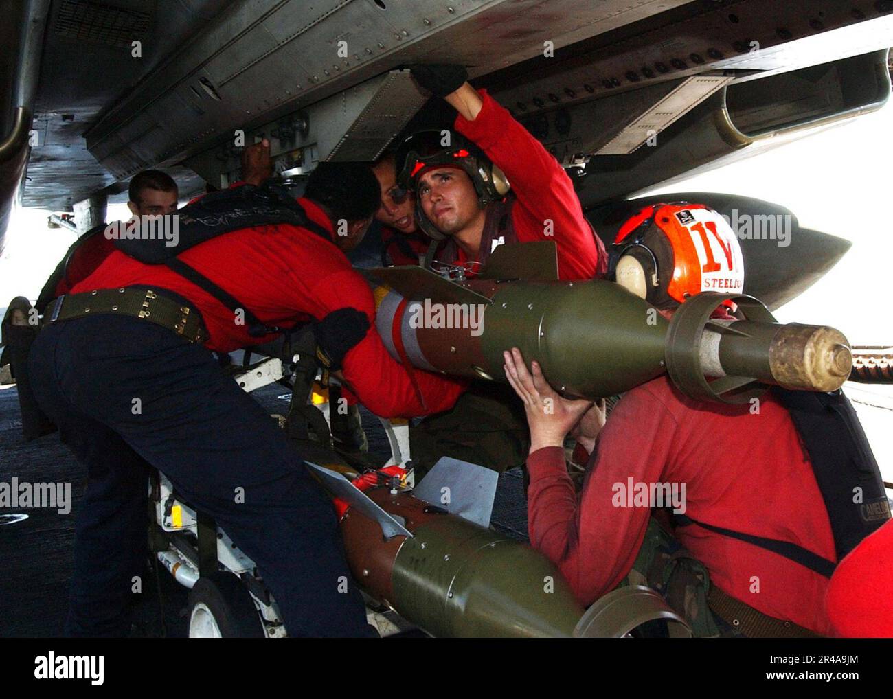 US Navy Aviation Ordnancemen load an Guided Bomb Unit-12 (GBU-12) onto ...