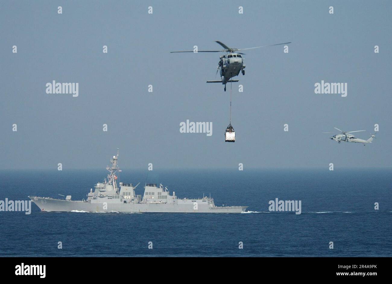 US Navy MH-60S Knighthawks conduct a vertical replenishment with the ...