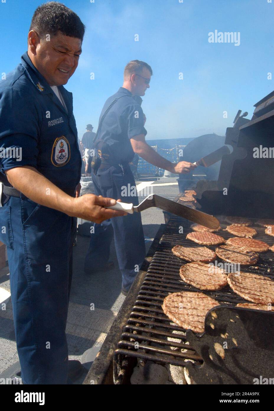 US Navy Boatswain's Mate 1st Class cooks hamburgers, hot dogs and ...